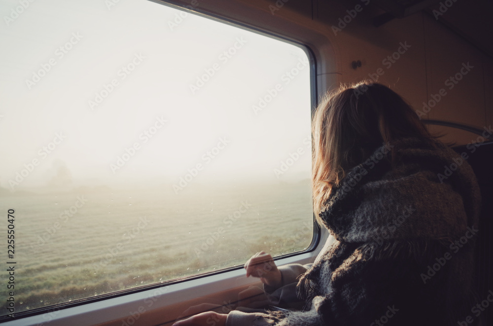 Girl in train looking through window Stock Photo | Adobe Stock