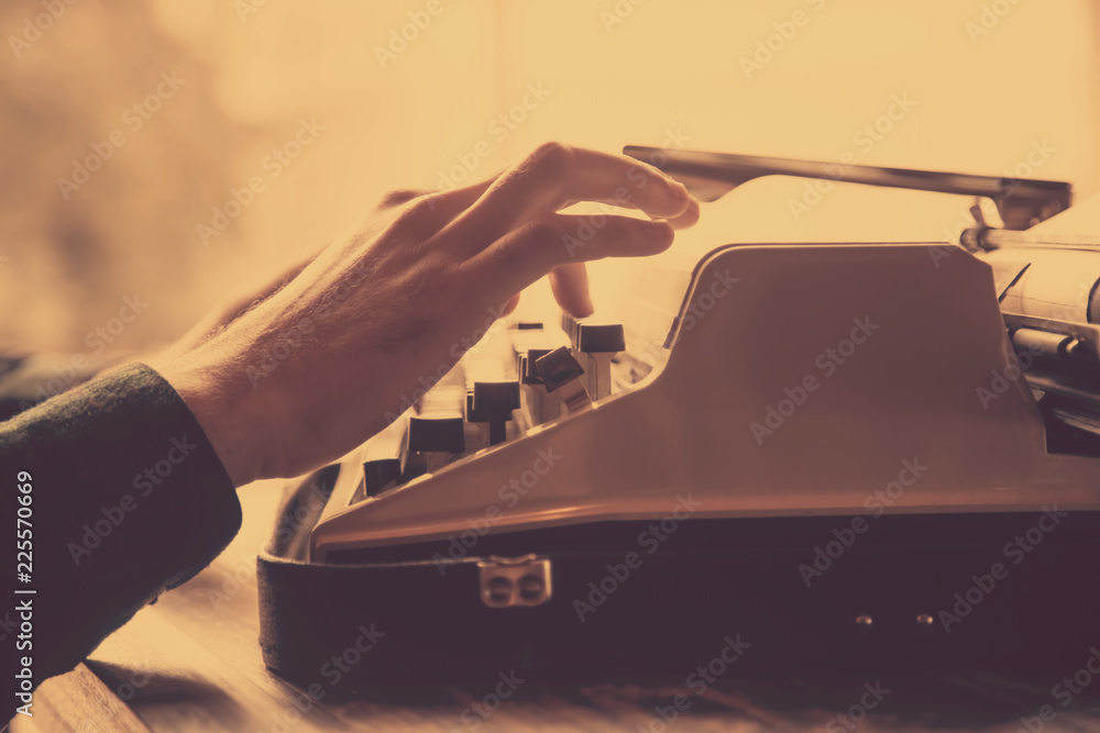 Foto de Journalist typing on an antique vintage typewriter machine as ...