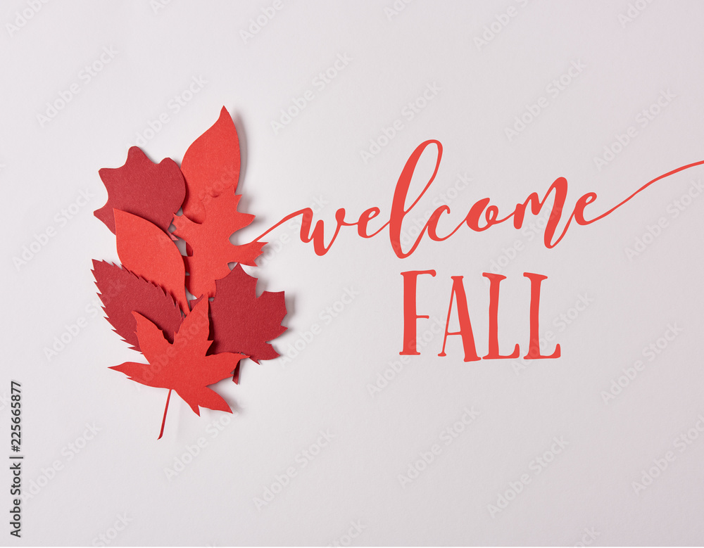 top view of red papercrafted leaves with "welcome fall" lettering on ...