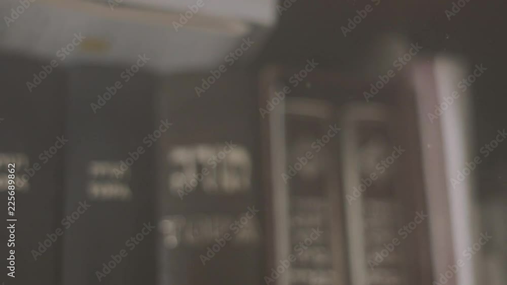 Cinematic shot of the Tora jewish books on a bookshelf, closeup with ...