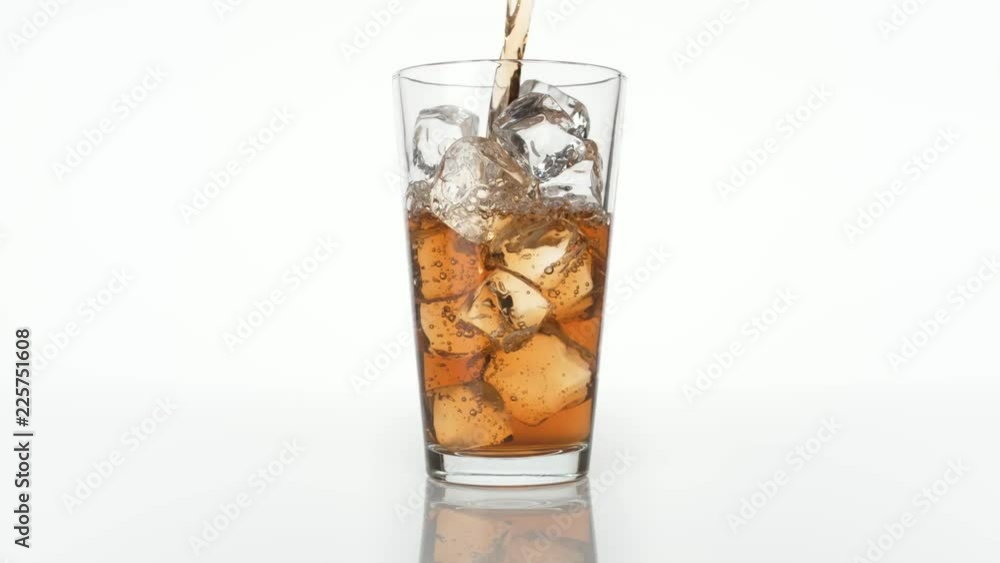 Loop of Pouring ice tea into glass with ice cubes . Shot with high ...