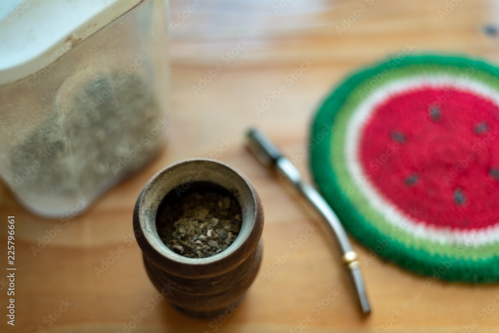 Mate with yerba mate, a tube for sipping, a jar with yerba and a ...