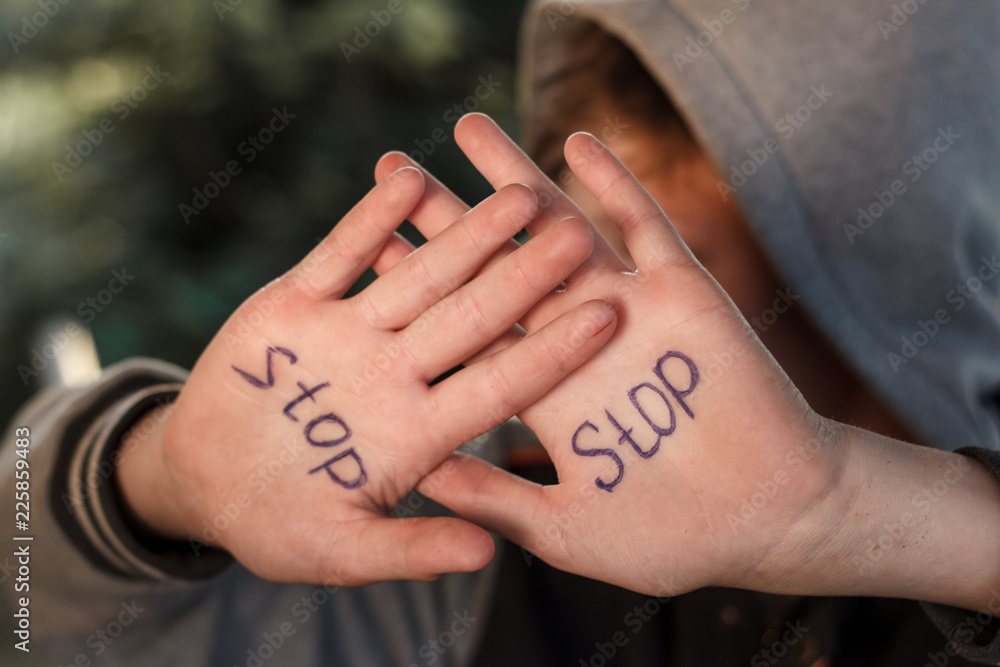 stop child abuse . Upset abused frightened little boy, stop hand ...