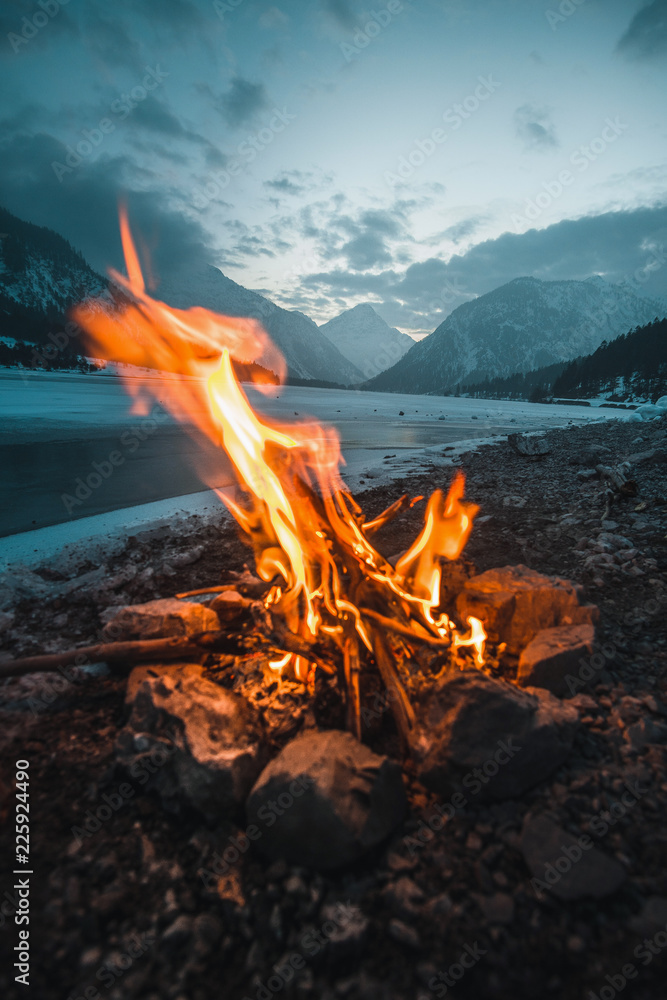 Winter campfire in the top of a frozen lake at night, a magnificent ...