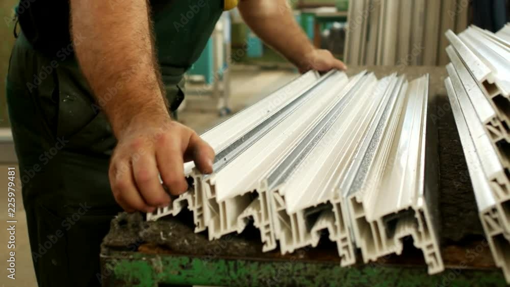 Production of pvc windows, male worker punctures the details of a pvc ...