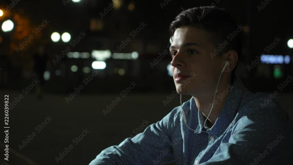 Emotional view of a pensive young man with short haircut sitting on a ...