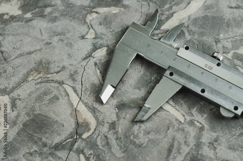 Vernier caliper of gray color on old cement floor with copy space for ...