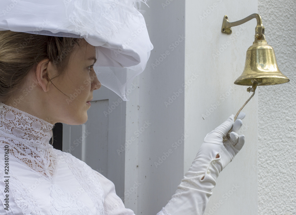 Edwardian woman ringing brass bell Stock Photo | Adobe Stock