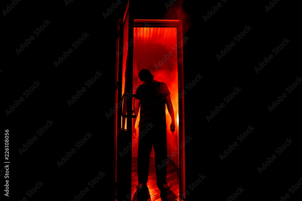 Silhouette of an unknown shadow figure on a door through a closed glass ...