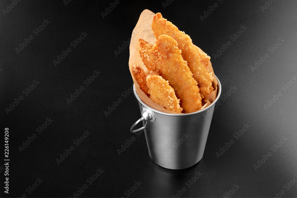 BBQ Chicken fried stripes in a metal bucket onblack background with ...