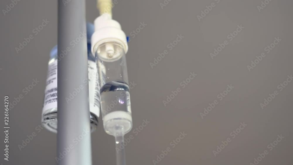 Close up of an antibiotic solution dripping through a medical patient's ...