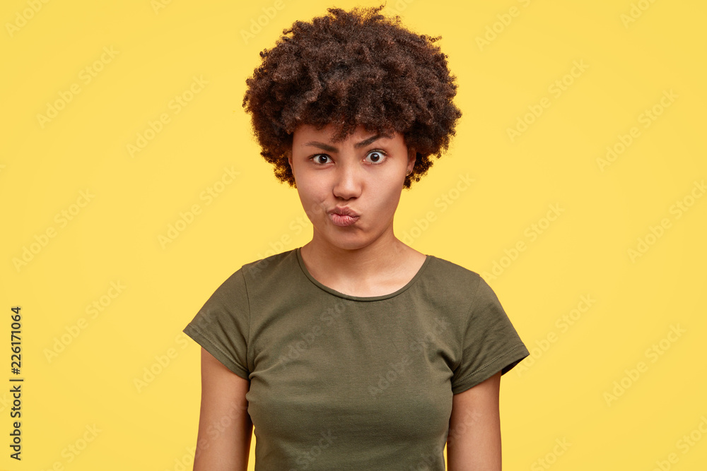 Dissatisfied woman frowns lips, has negative facial expression, dressed ...