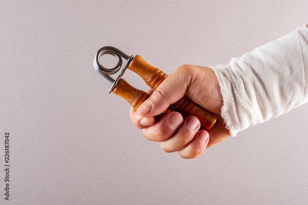 hurt hand doing rehabilitation exercises by squeezing an A shape hand ...