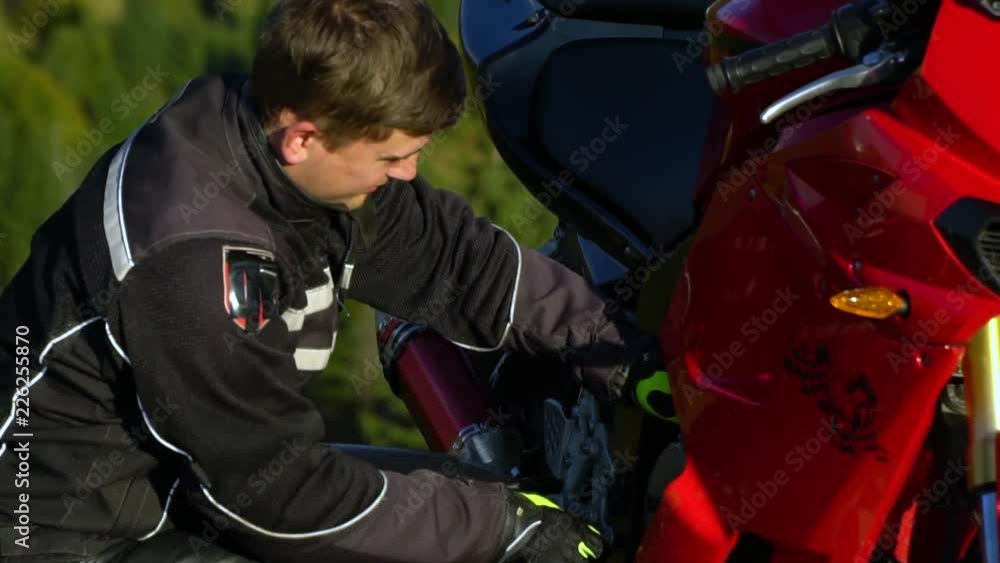 A guy on a motorcycle. Young handsome guy with his motorcycle in the ...