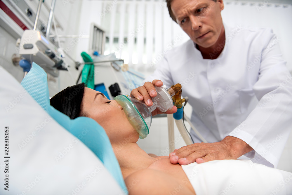 Female patient sleeping in hospital bed and getting mechanical ...