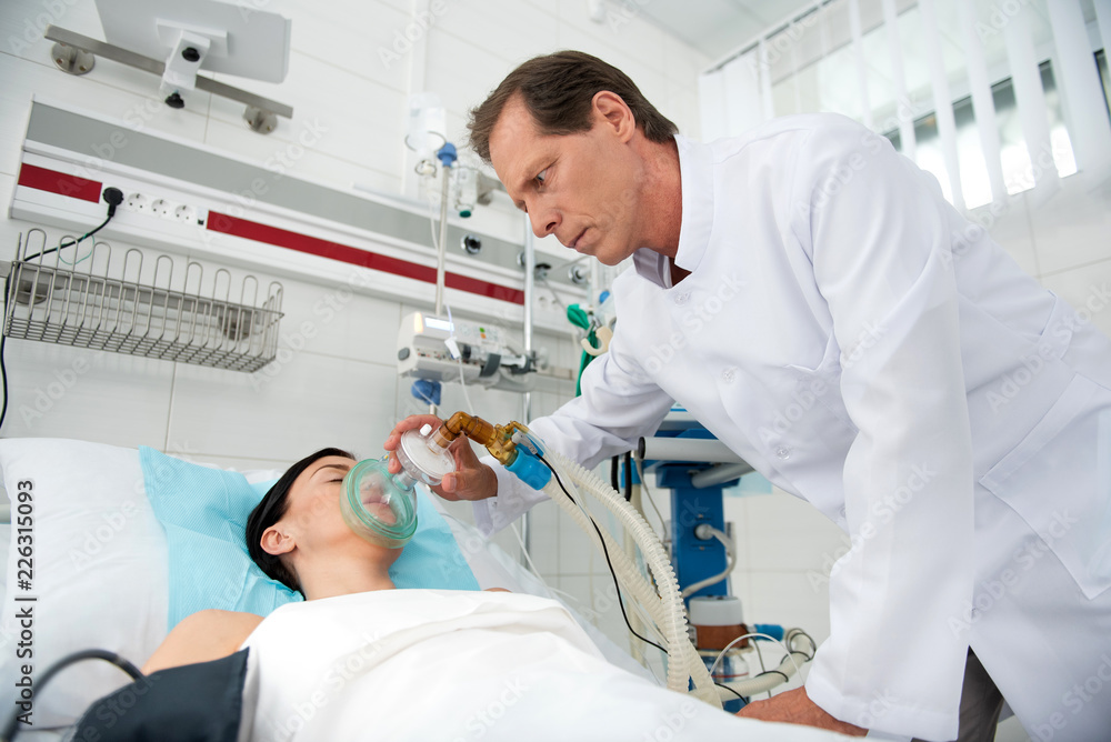 Female patient sleeping in hospital bed and getting mechanical ...