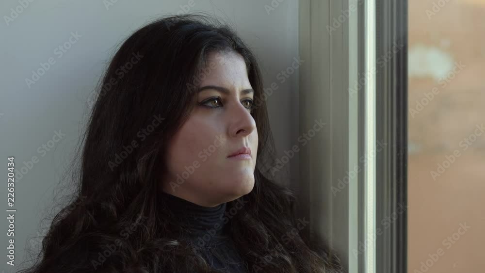 Sad thoughtful woman at the windows starts crying- close up Stock Video ...