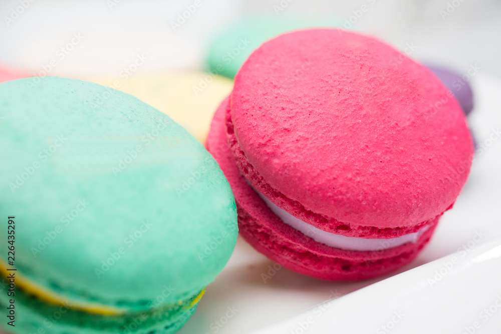 colorful magaroon is placed in a white ceramic dish. Elegant marble ...