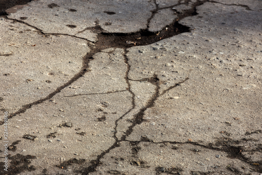 Damaged asphalt road with potholes, caused by freeze-thaw cycles in ...