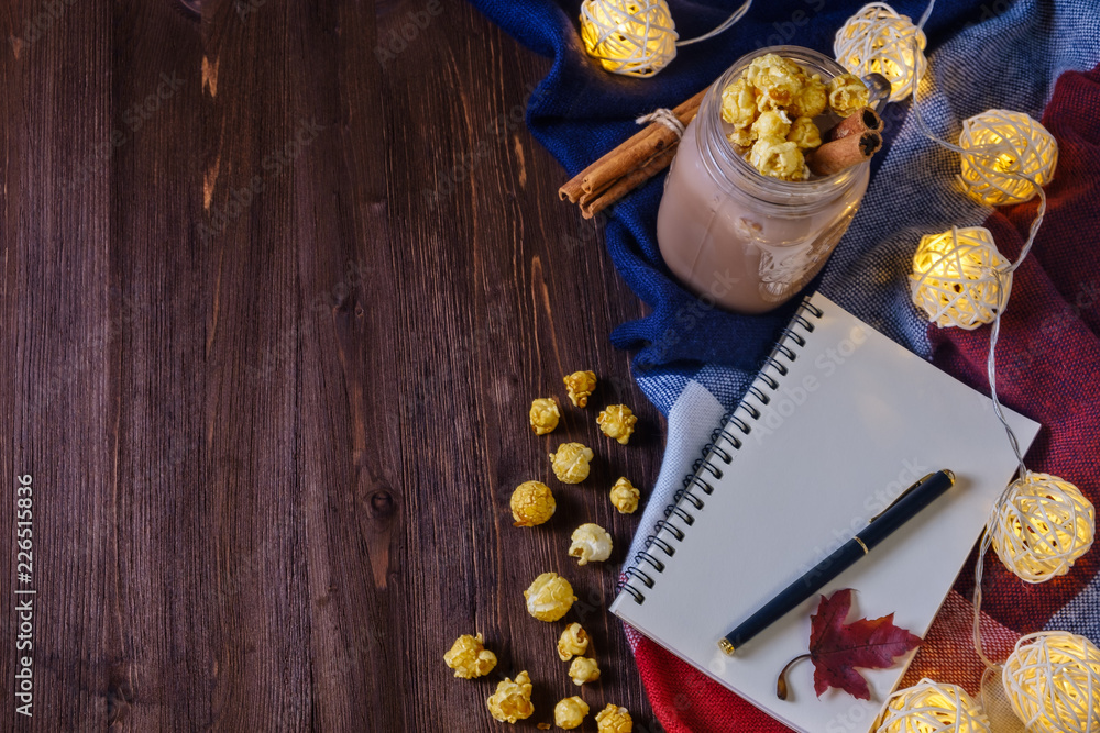 cocoa with popcorn and cinnamon on the table with an open notebook and ...