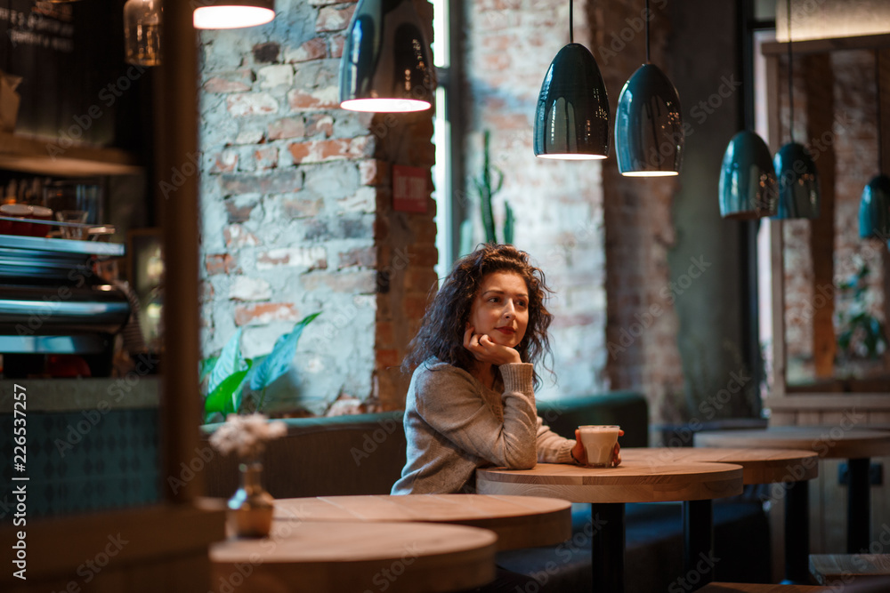 Cute woman having sleepy expression looking tired holding her hand on ...