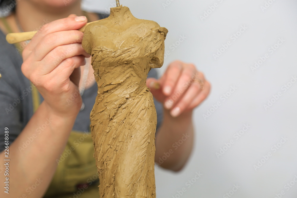 Sculptor artist creating a bust sculpture with clay. She is happy of ...