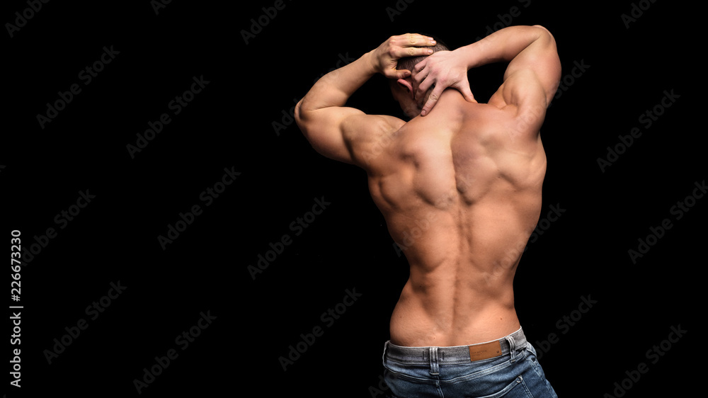 The back view of torso of attractive male body builder on dark ...