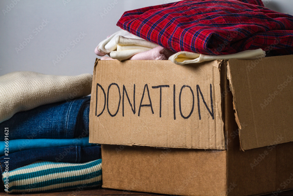 Donation concept. Donation box with donation clothes on a table ...