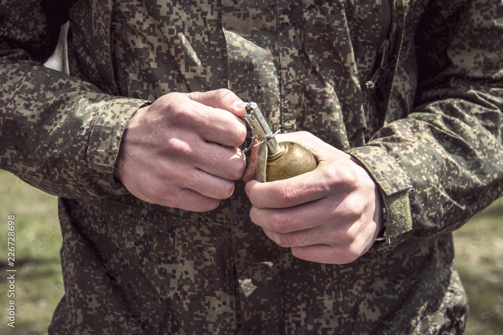 Grenade, Hands on Pin. the soldier pulls a check from a fragmentation ...
