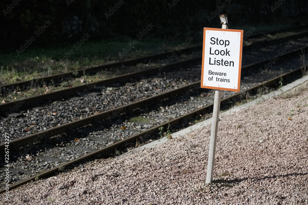 Stop look listen safety road sign at railway train station danger ...