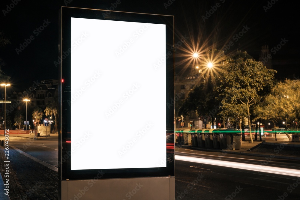 Light box advertisement with white blank space by road in street. Night ...