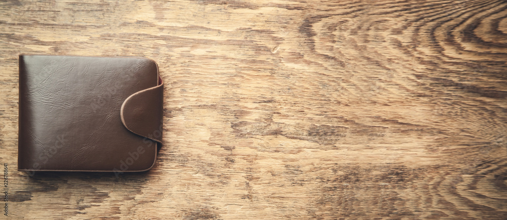 Brown wallet on a wood background. Stock Photo | Adobe Stock