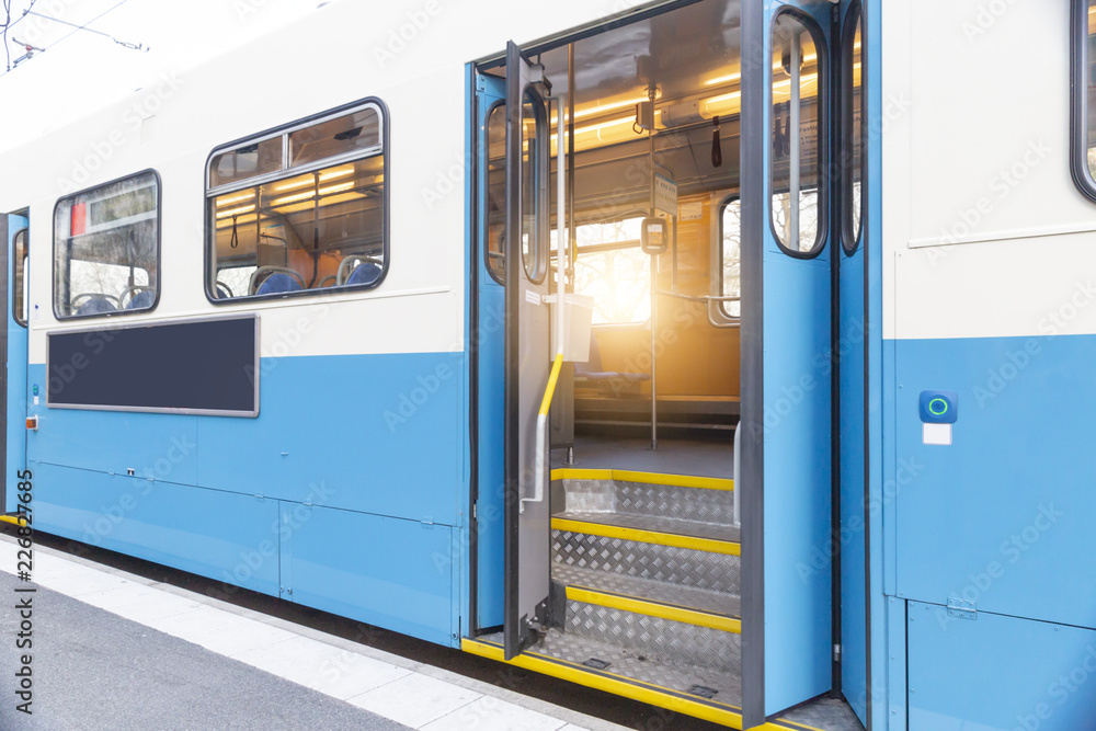 Tram stop on tramway, door opened, big empty advertising board with ...