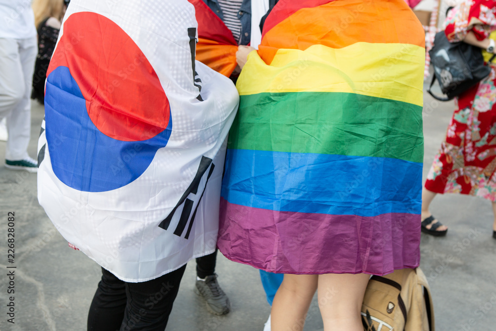 Lgbt Couple With Rainbow Flag And South Korean Flag On City Street In