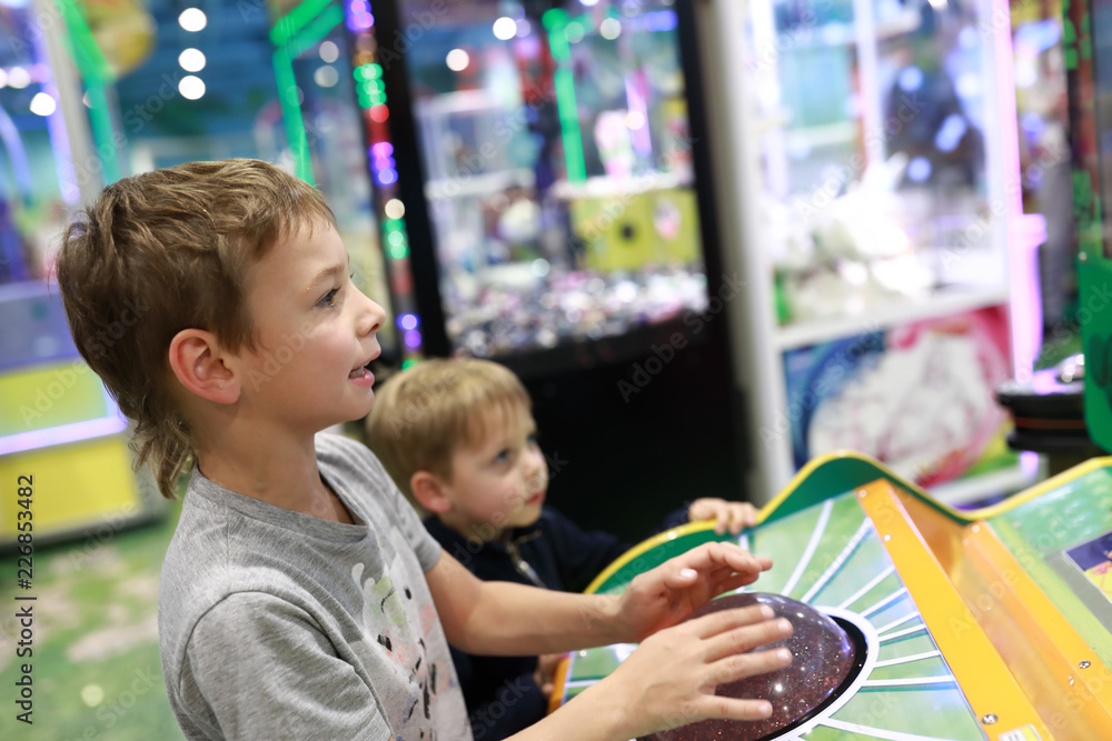 Brothers playing arcade game Stock Photo | Adobe Stock
