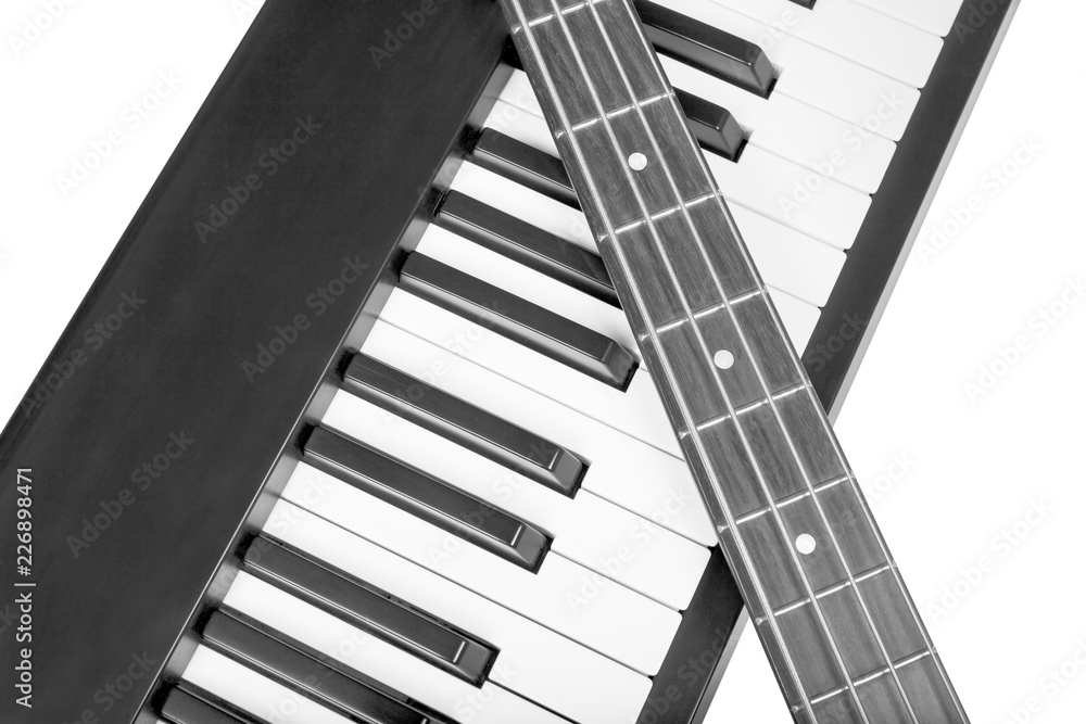 Bass guitar laying across a piano keyboard Stock Photo | Adobe Stock