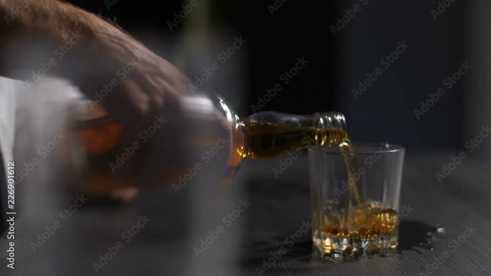 Closeup of wasted alcoholic man with shaking hands trying to refill ...