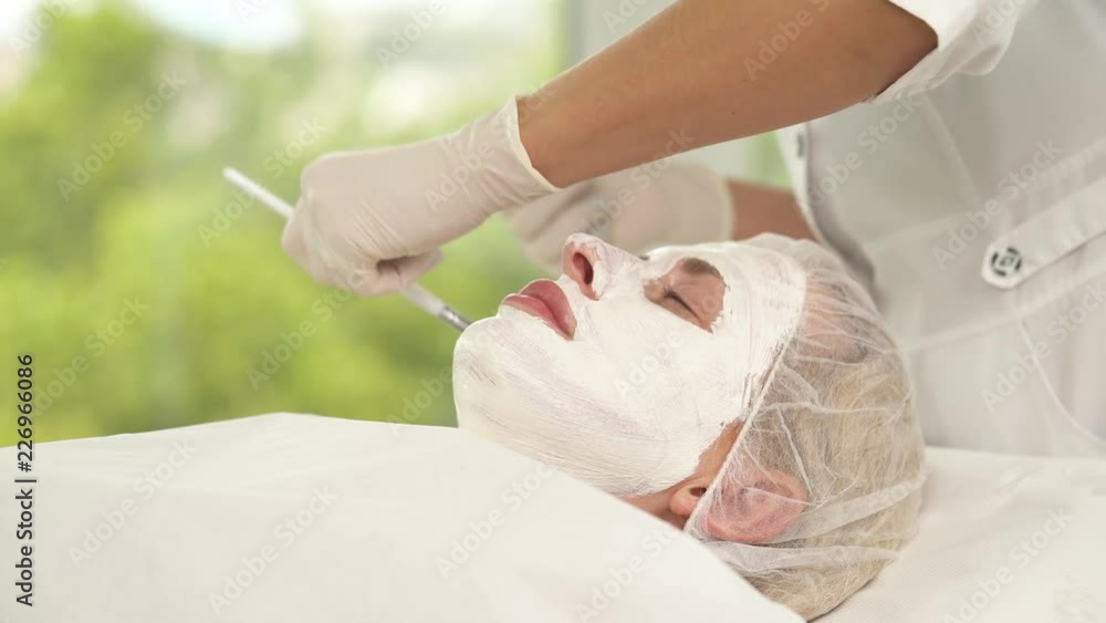Video Stock A side view of a woman's face covered with white mask. A ...