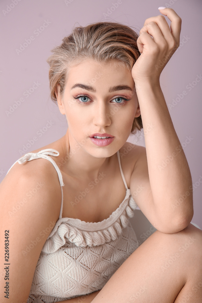 Beautiful young woman with nude makeup on color background Stock Photo | Adobe Stock