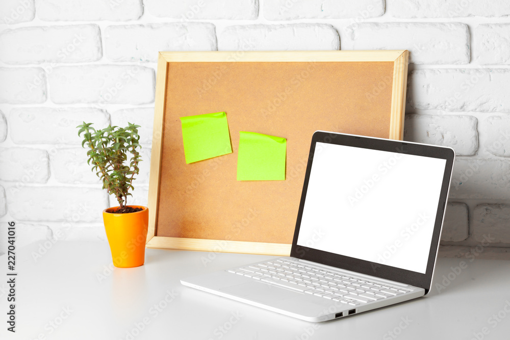 Office table with laptop and bulletin board on it. Business details ...
