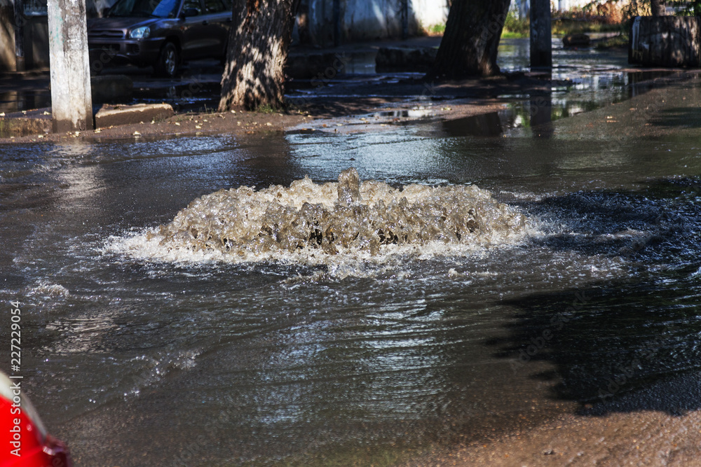 Water flows out of road sewage hatch. Drainage fountain of sewage ...