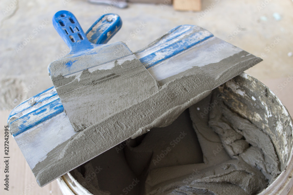 spatula with bucket of glue,ready-made solution of glue in a bucket ...