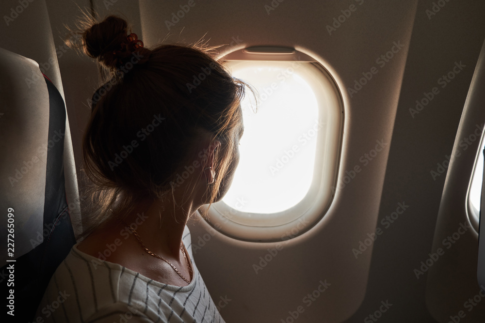 Girls looking out the window of the plane. Stock Photo | Adobe Stock