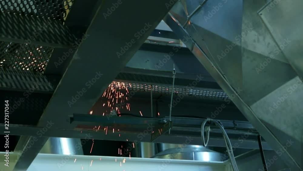 Construction of the industrial factory. Falling sparks while grinding ...