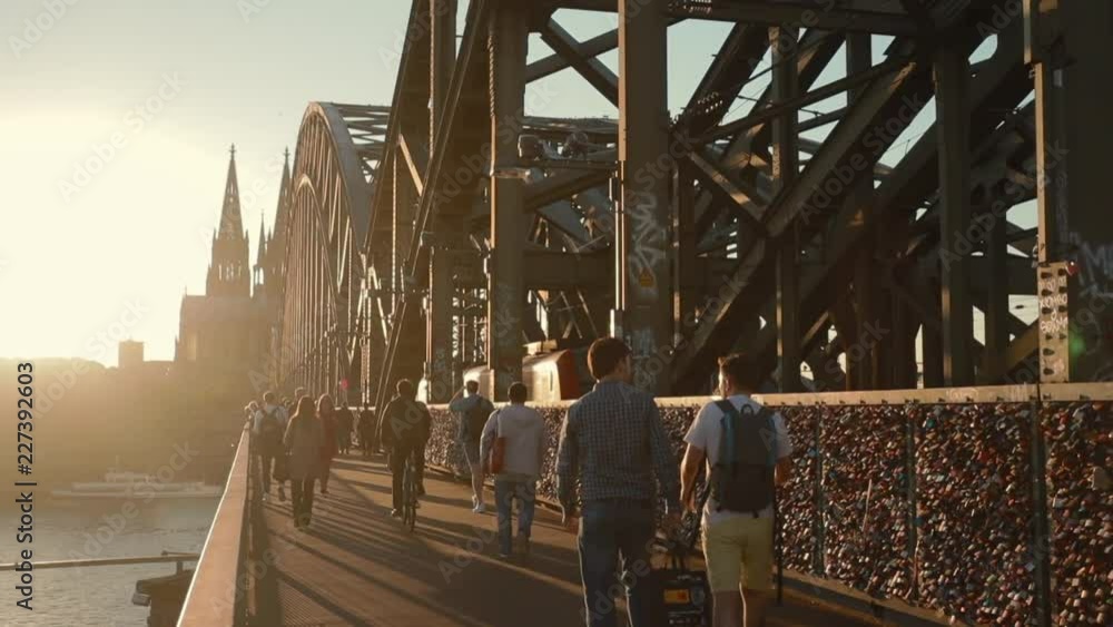 People walking on busy pedestrian pathway with train passing in the ...
