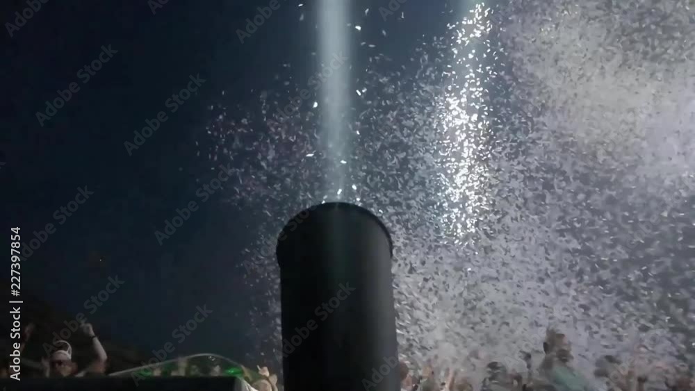 confetti blower, blowing confetti over a crowd. white confetti. filmed ...