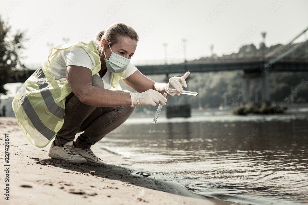 Water contamination. Professional sanitary inspector holding test tubes ...