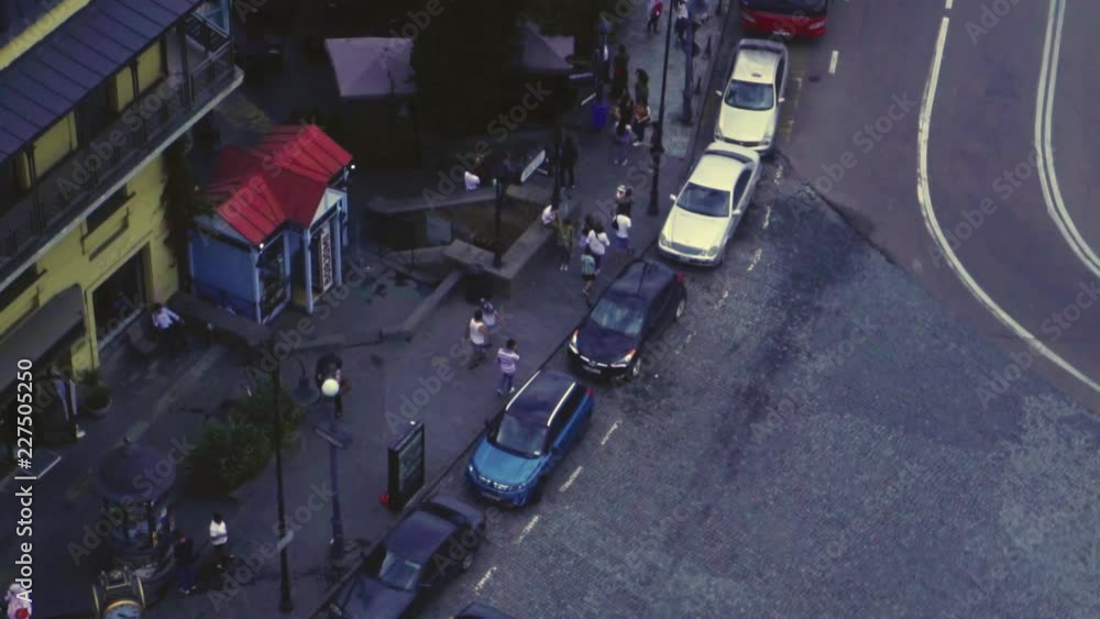 Road traffic cars along the street with walking people in urban daily ...