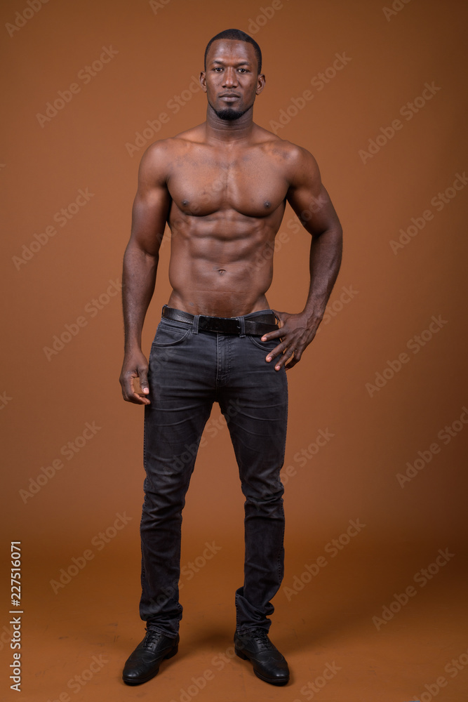 Handsome muscular African man shirtless against brown background Stock ...