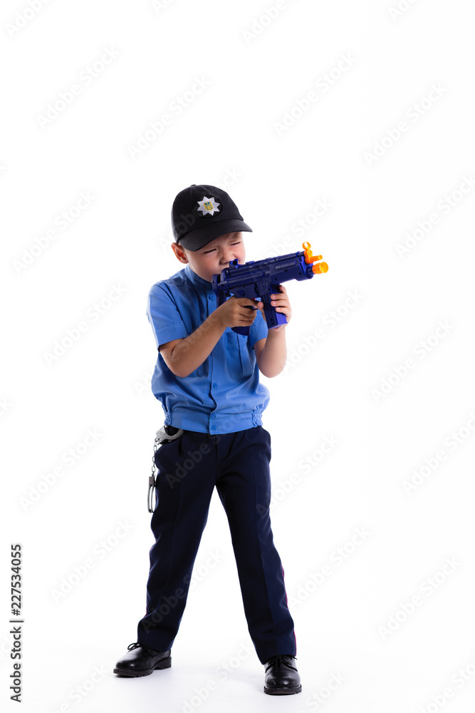 Cute little police boy with smile on face and gun on white background ...